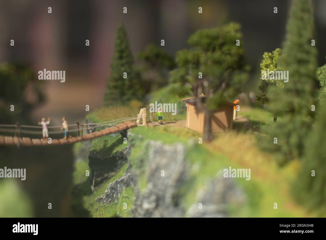 Toy model of park. People on bridge. Tourists in mountains in summer ...