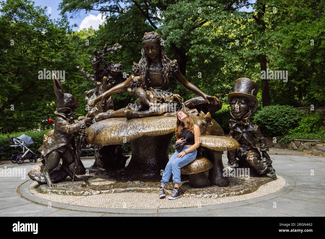 Young teen girl posing in the statue of Alice in Wonderland in Central ...
