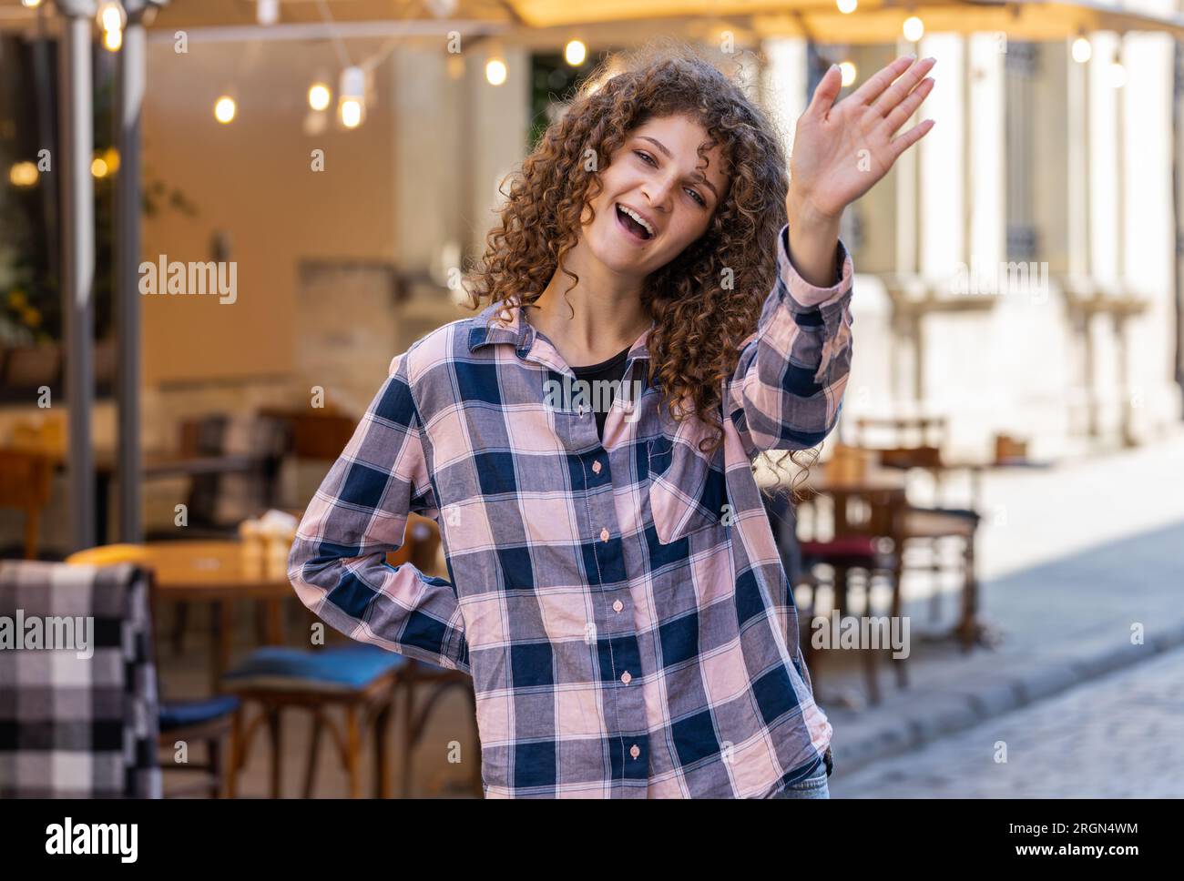 Hello. Young pretty woman smiling friendly at camera, waving hands ...