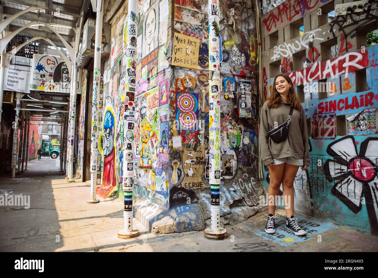Teenager girl posing and smiling with graffiti art walls in Freeman ...