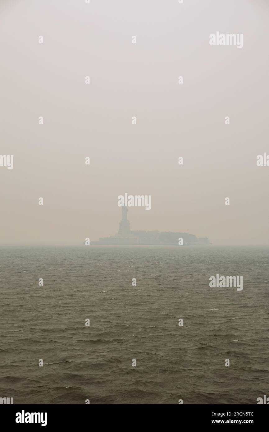 Statue of Liberty on a misty / smokey day seen from the Staten Island ...