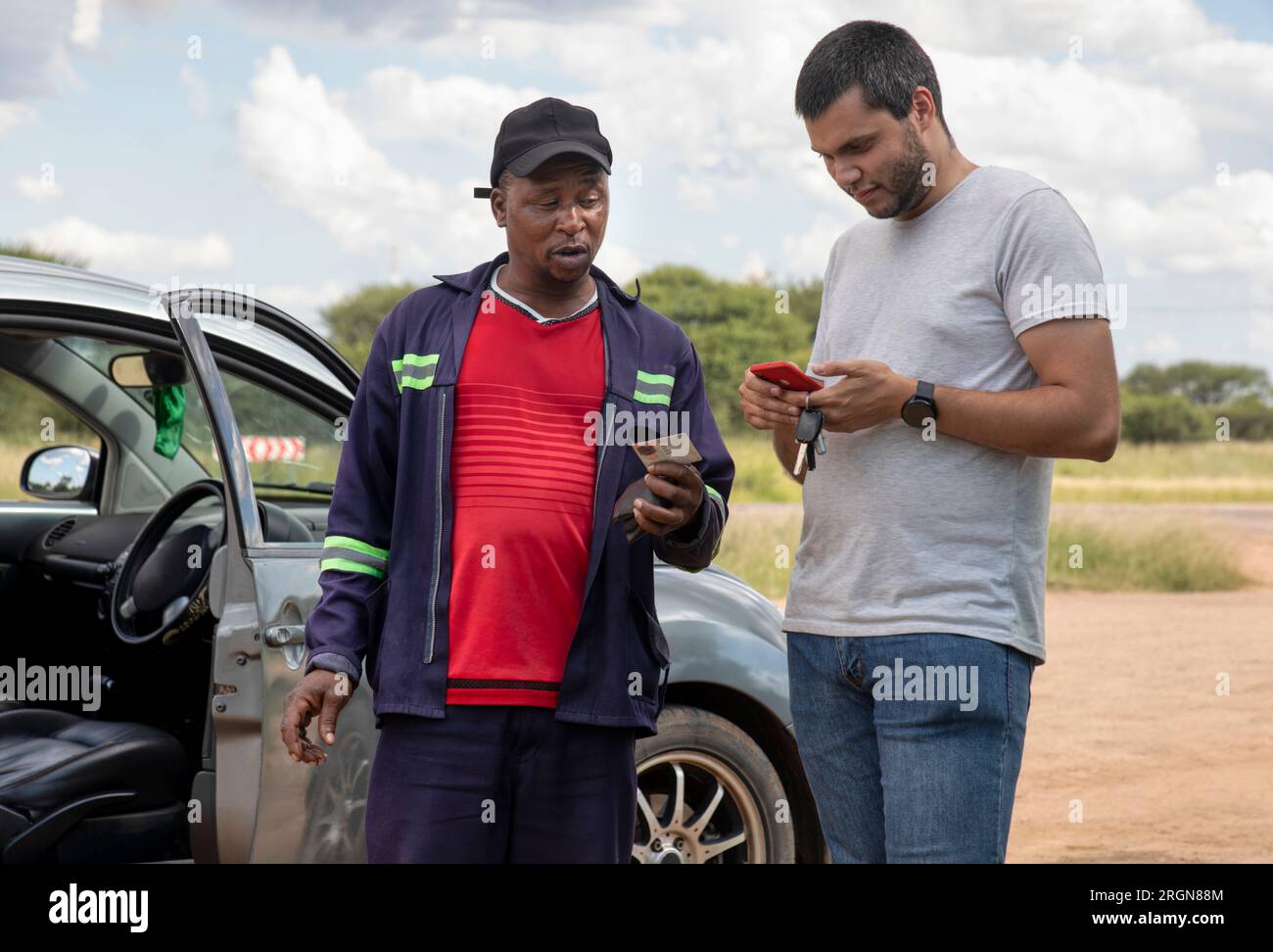two drivers exchanging insurance information after an accident pulled ...
