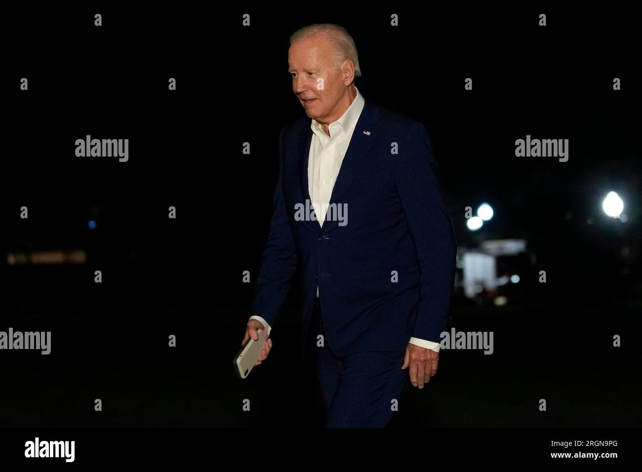 President Joe Biden walks across the South Lawn of the White House in ...