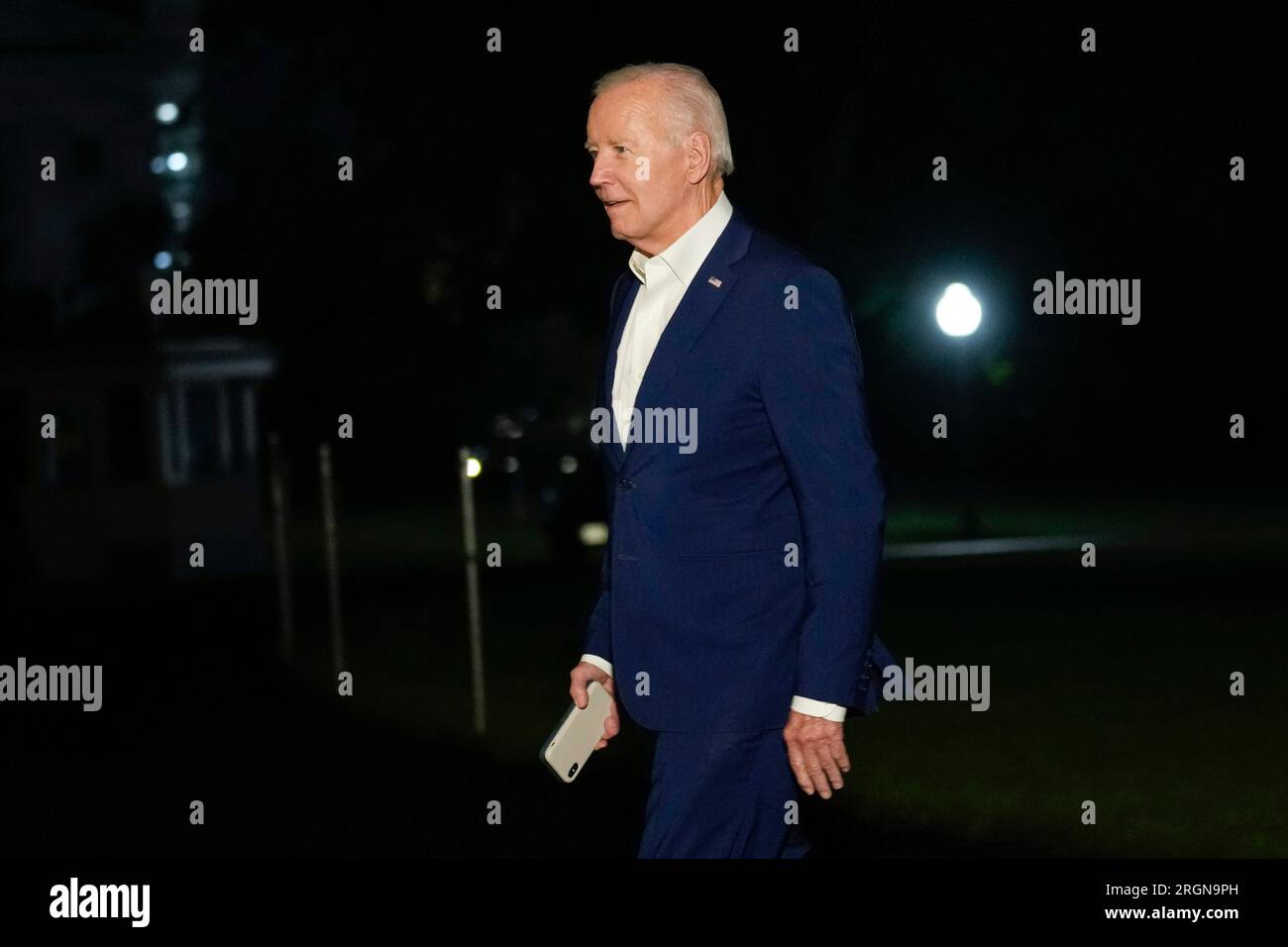 President Joe Biden walks across the South Lawn of the White House in ...