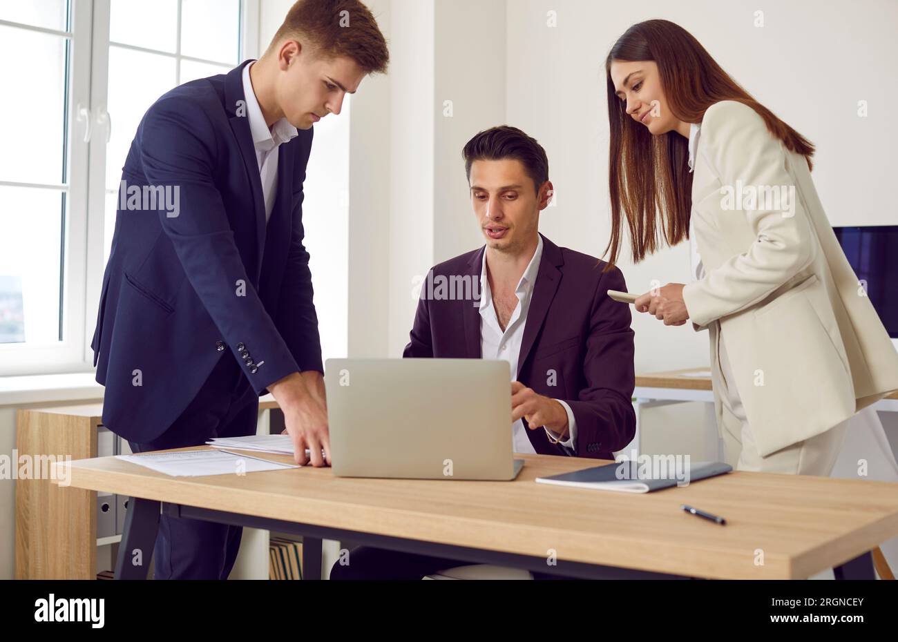 Male employee showing something to his colleagues on the monitor screen ...