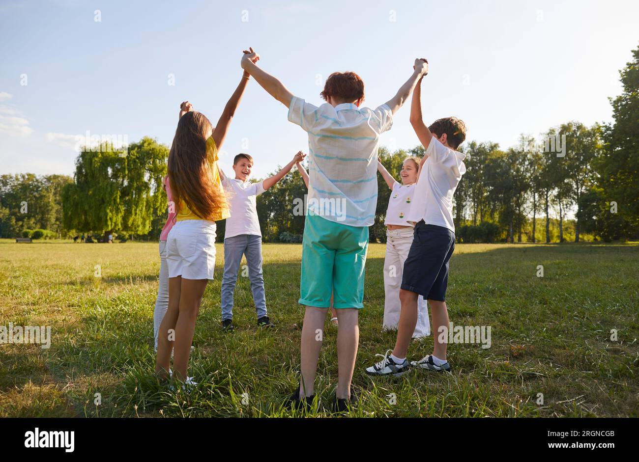 Children standing in circle holding hands and playing games together ...