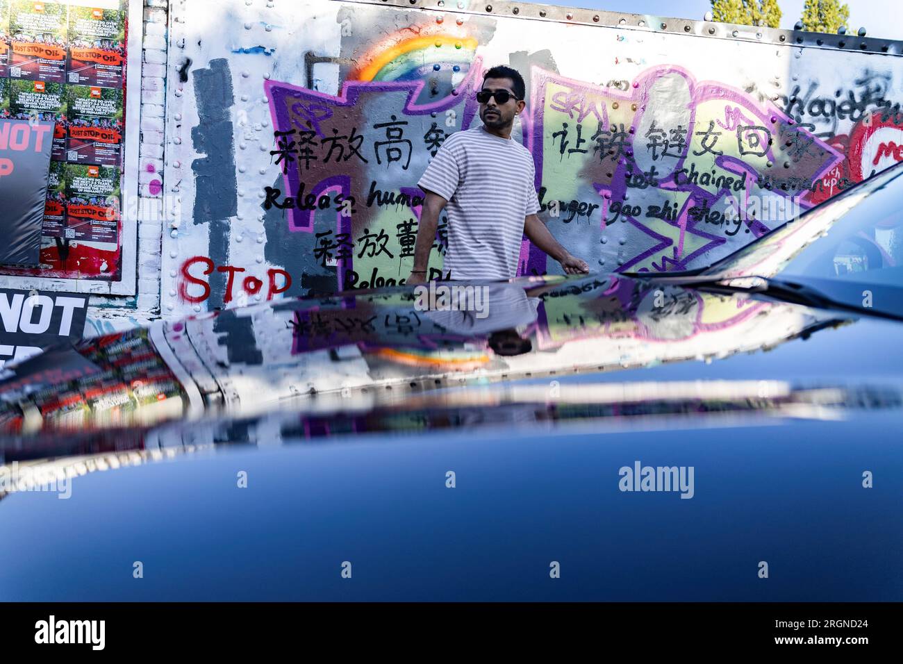 A man walks past anti-Beijing counter-slogans in Brick Lane. "Brick ...