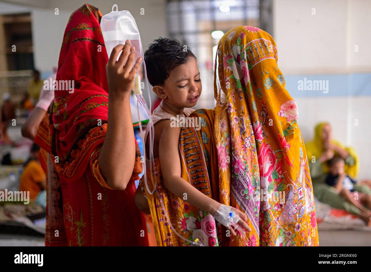 A child is carried by his mother as he receives treatment for dengue at Mugda Medical College ...