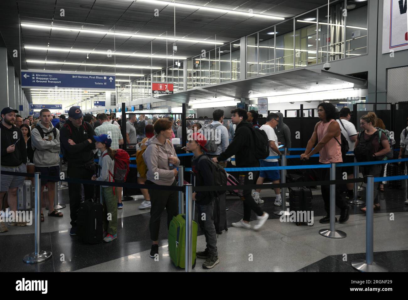 Passengers stand in line at a TSA security checkpoint in Terminal 3 at ...