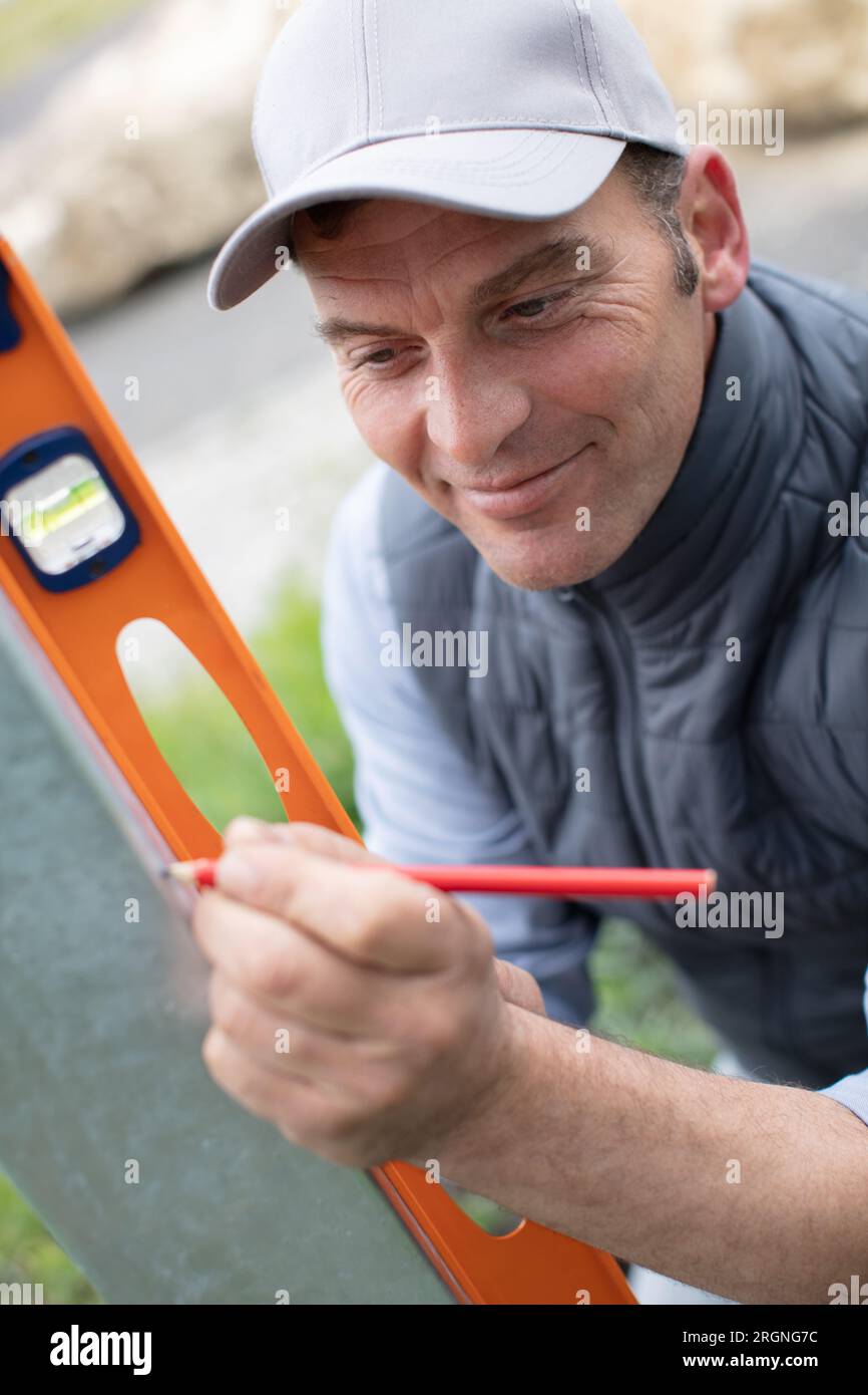 worker with pencil with a spirit level Stock Photo - Alamy