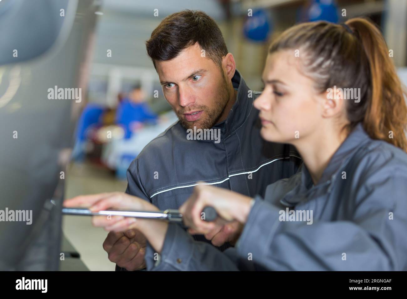 two mechanics operating wheel equilibrium control machinery Stock Photo ...