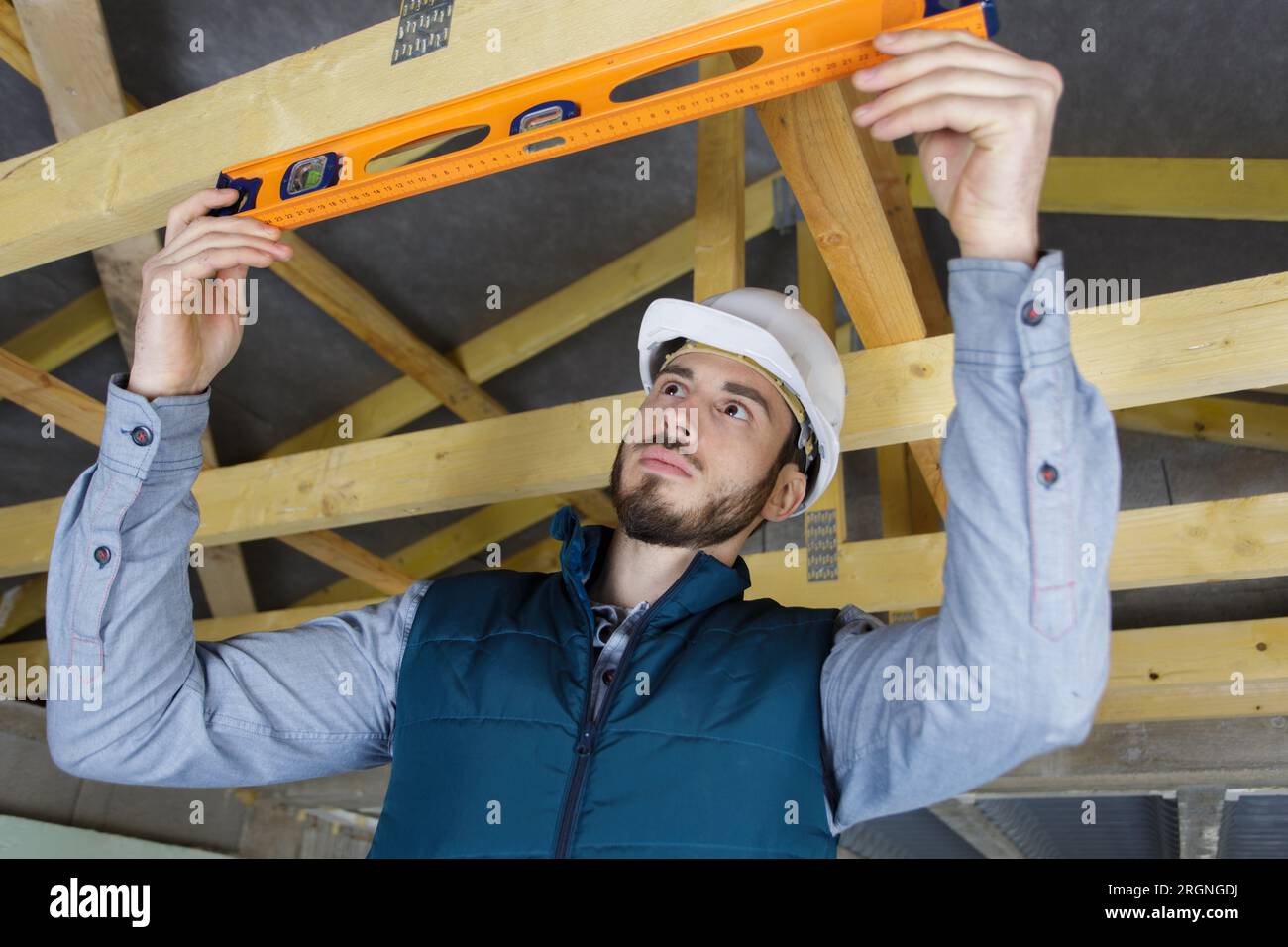 construction site worker with spirit level checking beam Stock Photo - Alamy