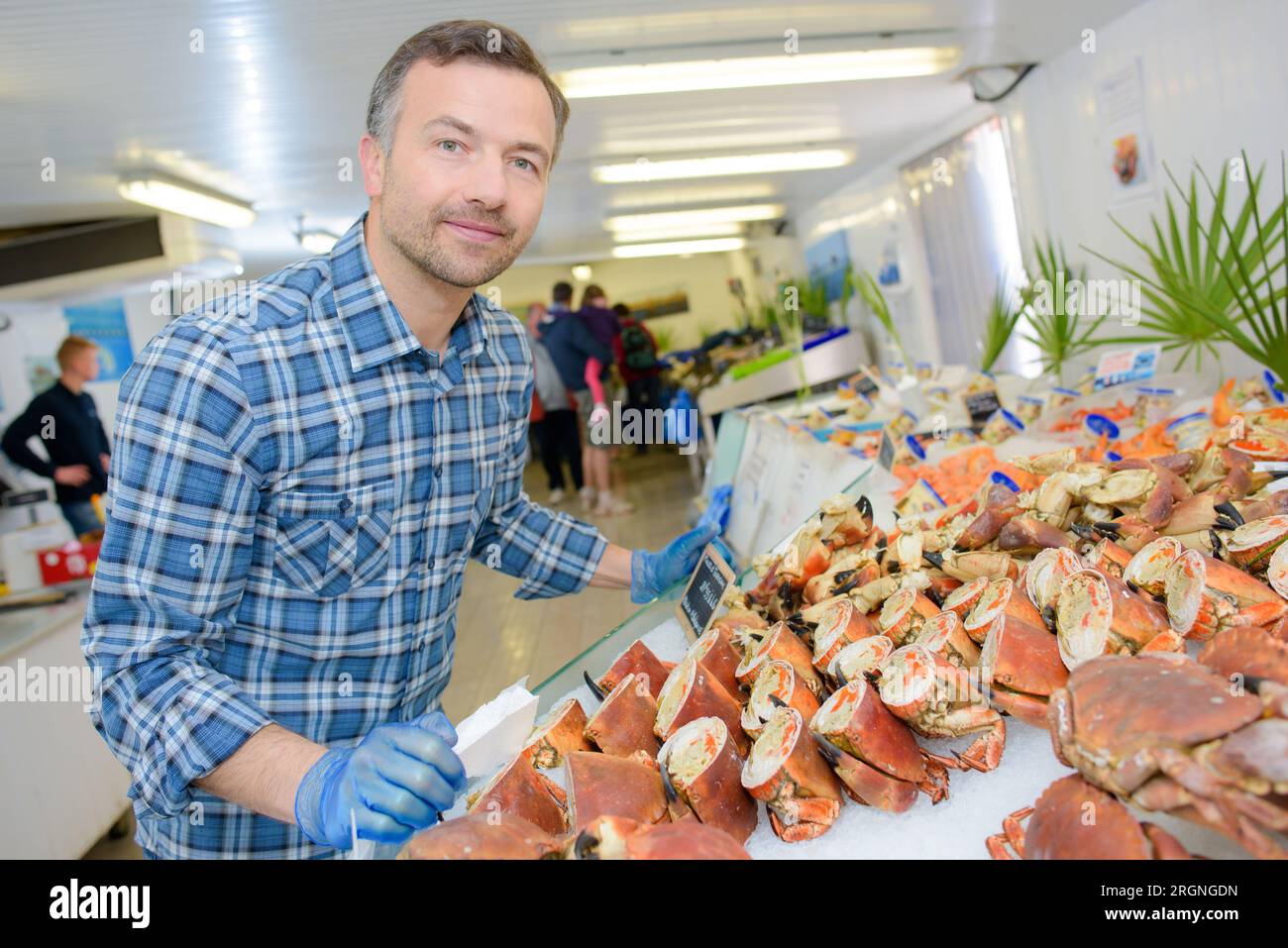 Fishmonger in front of market stall Stock Photo - Alamy