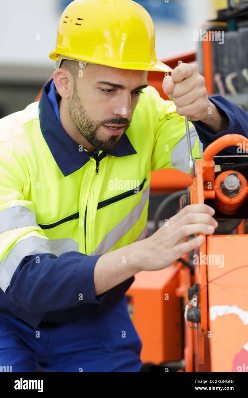 young male engineer standing beside a tractor Stock Photo - Alamy