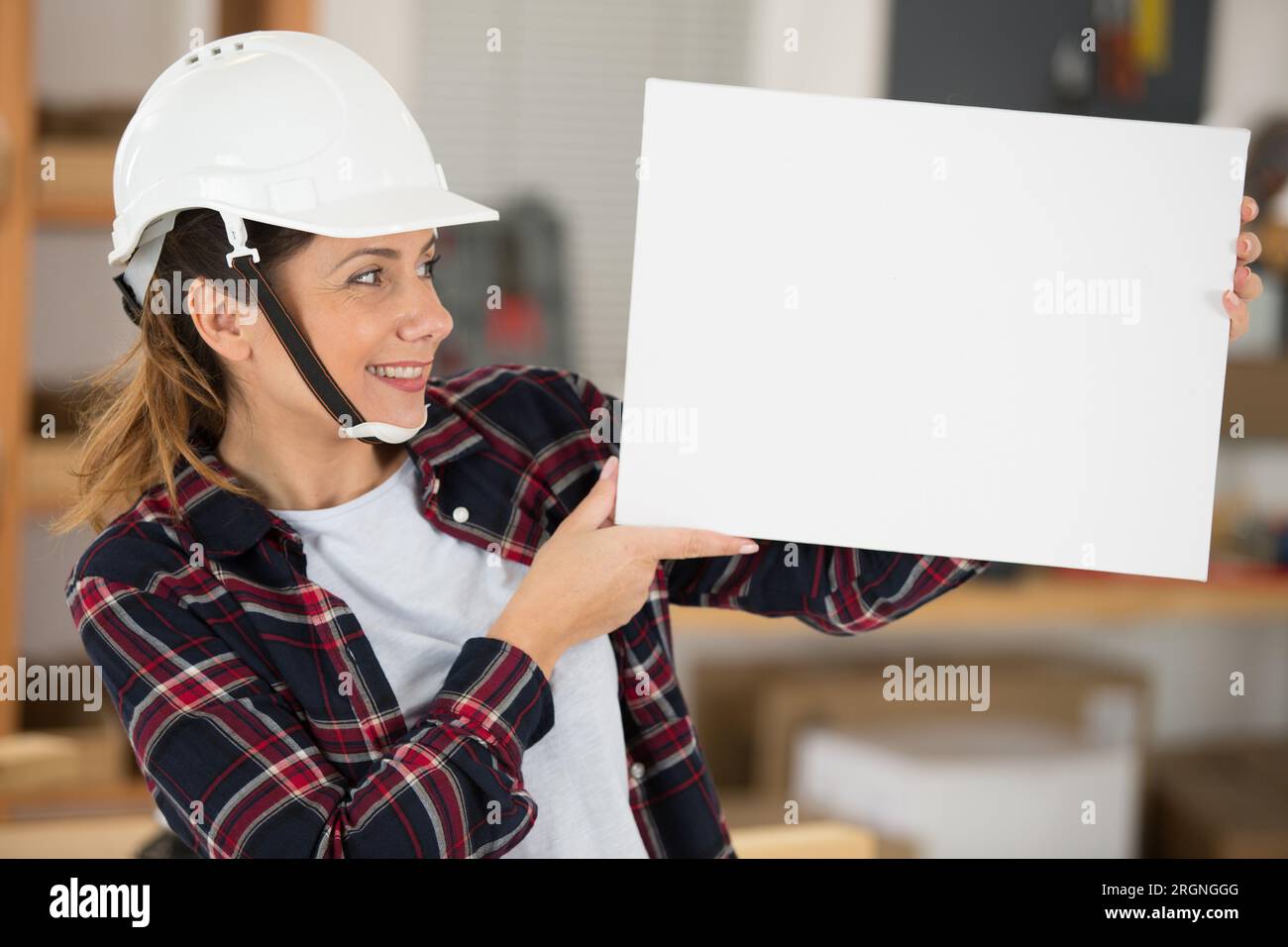 beautiful female construction manager holds white board Stock Photo - Alamy