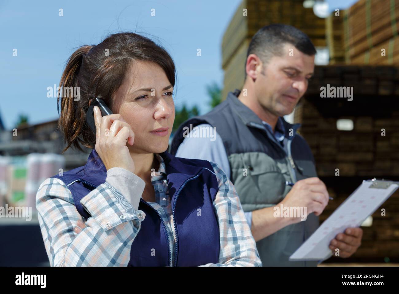 worker using telephone in building materials yard Stock Photo - Alamy
