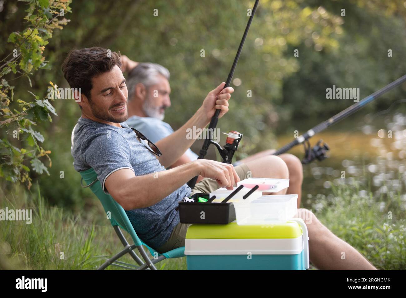 two male friends fishing together on the lake Stock Photo - Alamy