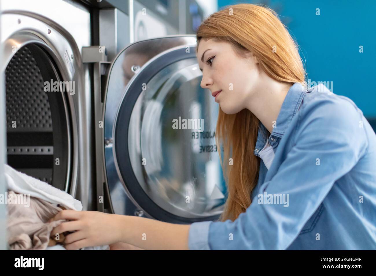 beautiful female employee working at laundromat shop Stock Photo - Alamy