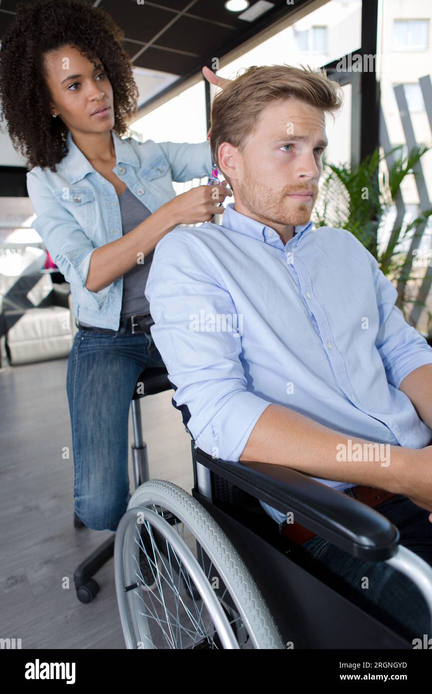a disabled man having haircut Stock Photo - Alamy