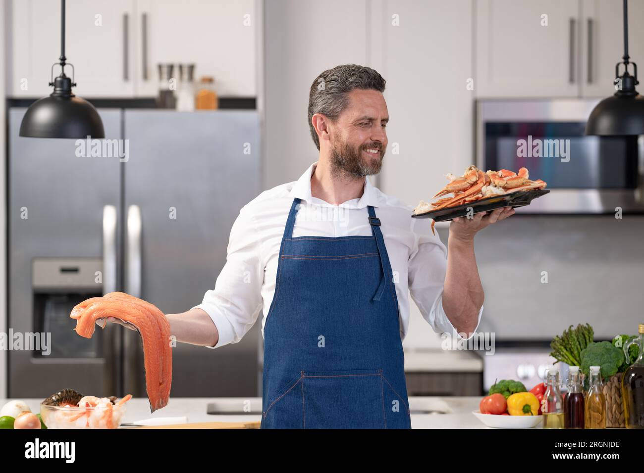 smiling chef with lobster and salmon seafood. chef cooking lobster and ...