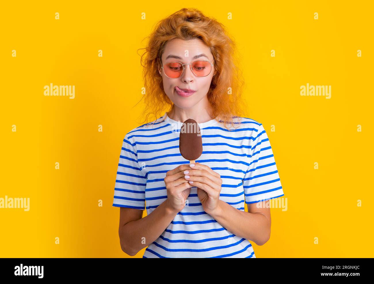 photo of hungry girl with icelolly ice cream at summer. girl with ...