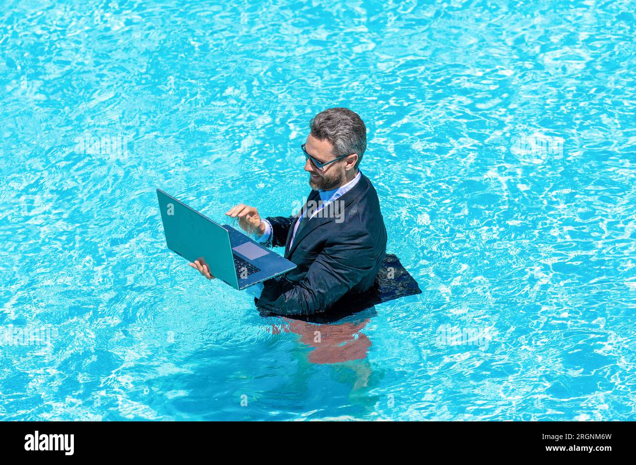 businessman in wet suit in swim pool. Remote working. Summer business ...