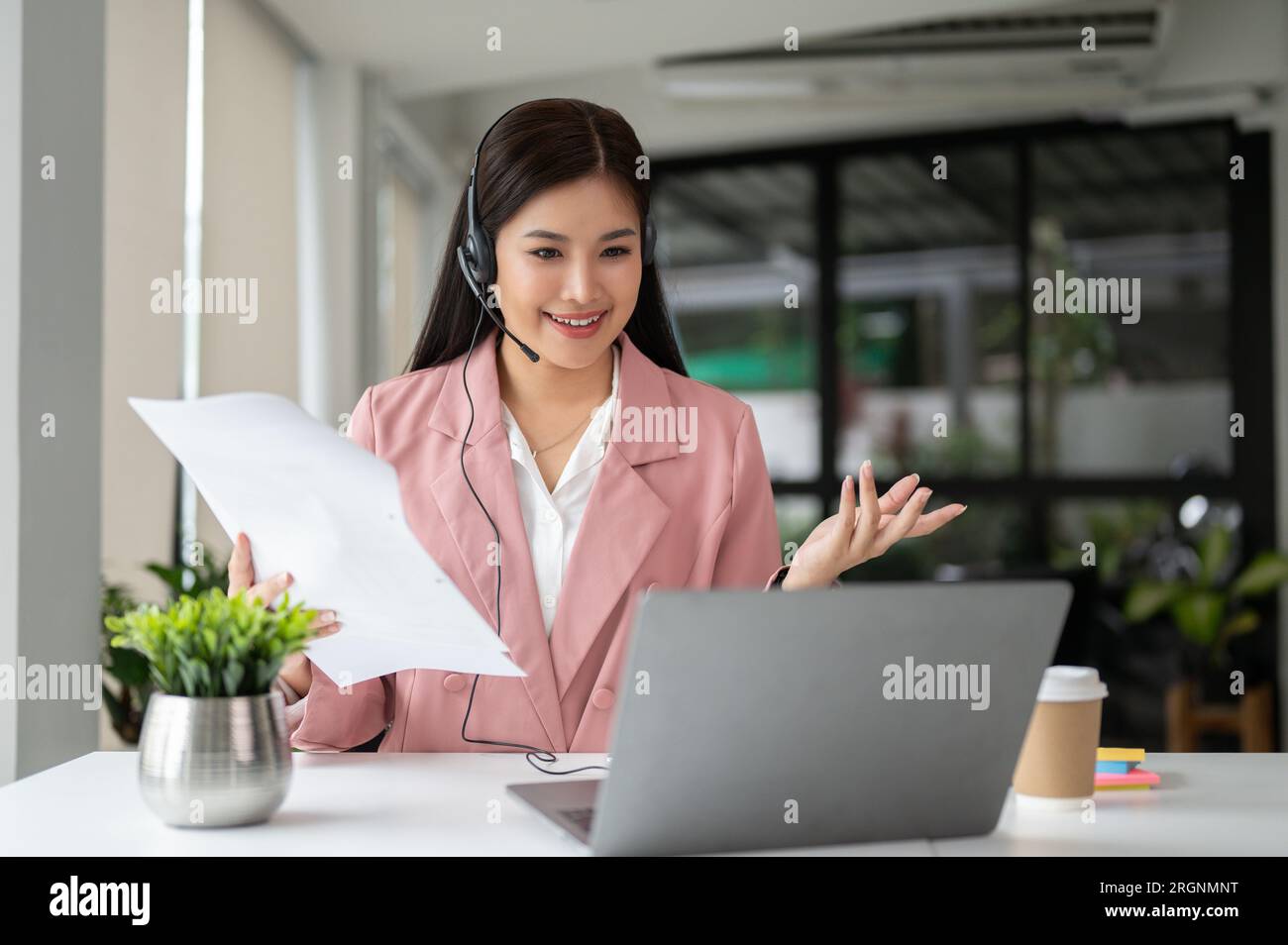 A professional and beautiful Asian female customer service operator or call-centre agent in ...