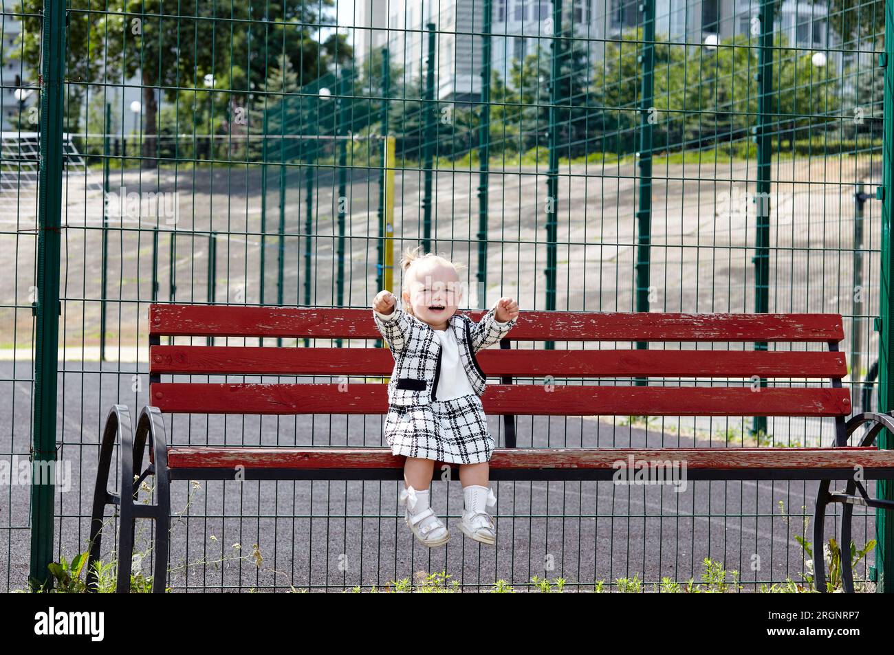 Sad little girl sitting on a bench and waiting for mom. Child loss in ...