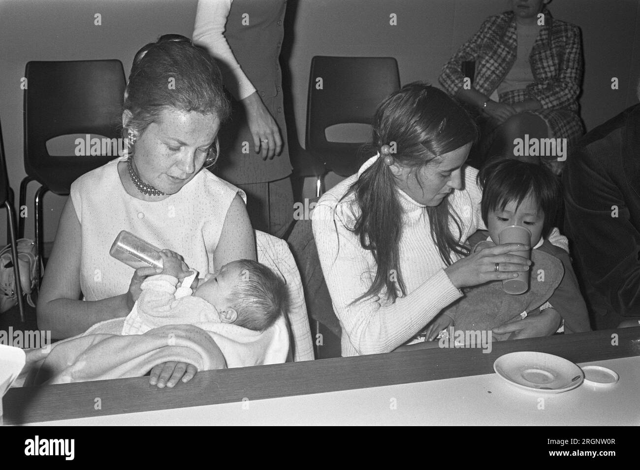 Korean orphans at Schiphol, women feeding two Korean babies ca. 1972 ...