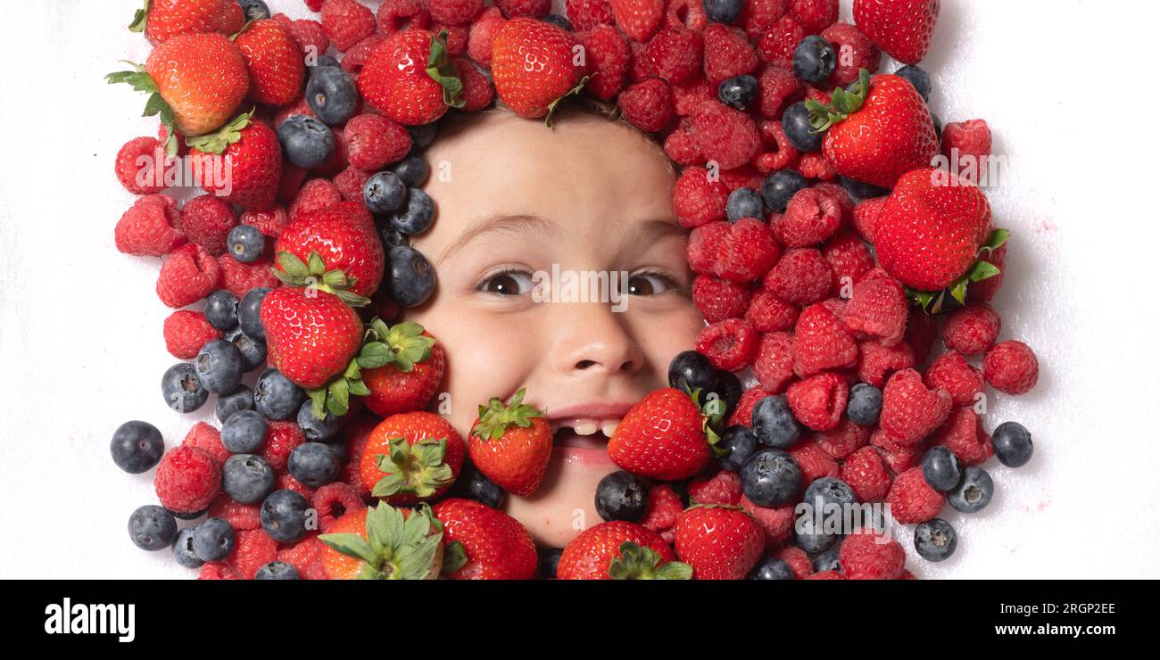 Summer fruits. Kids face with close-up berry. Berries mix of strawberry ...