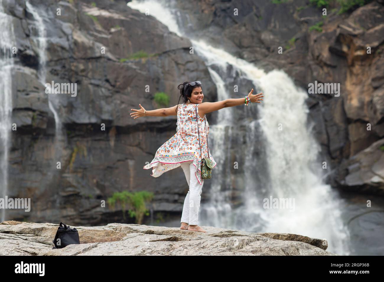 An Indian female girl woman enjoying natural beauty of waterfall with ...