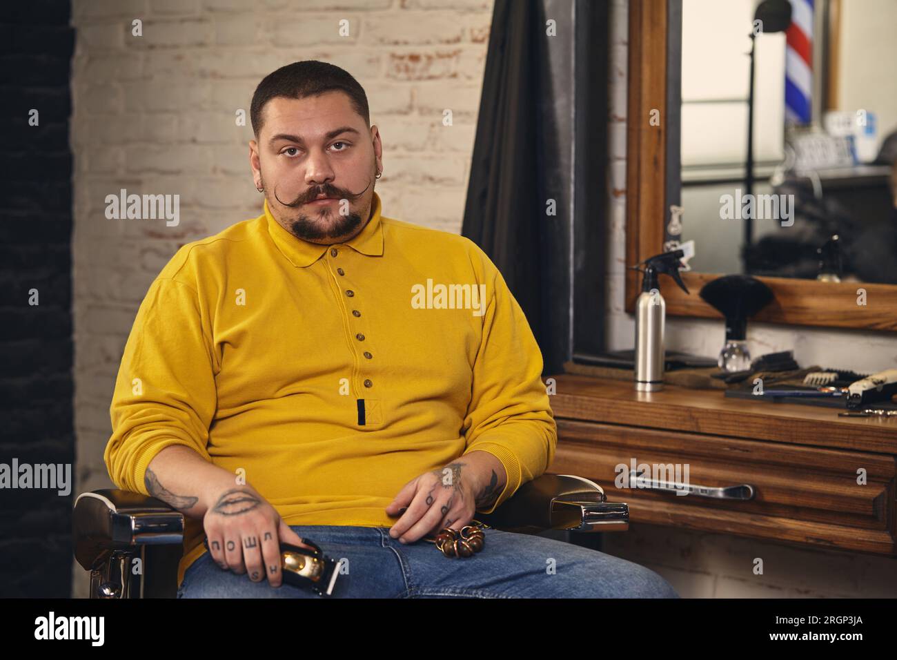 Stylish barber man with hairdressing tools in his hands prepare for ...