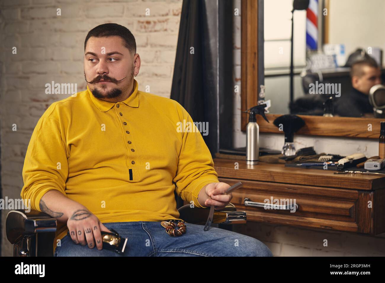 Stylish barber man with hairdressing tools in his hands prepare for ...