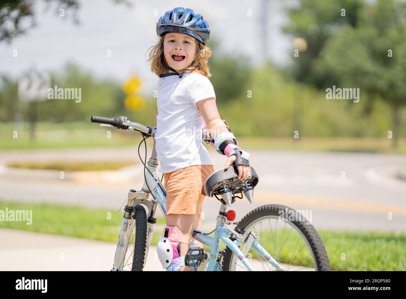 Kid riding bike in a helmet. Child with a childs bike and in protective ...
