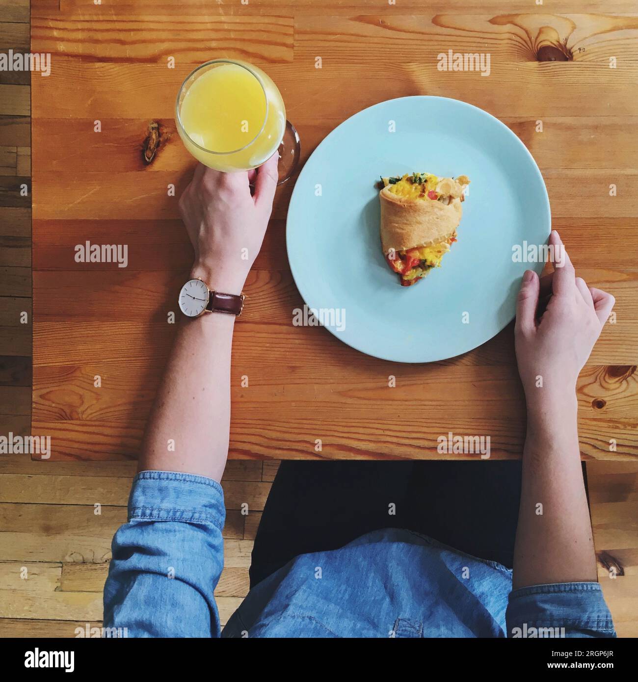 Bird's eye view of a woman about to enjoy a savory pastry and mimosa ...