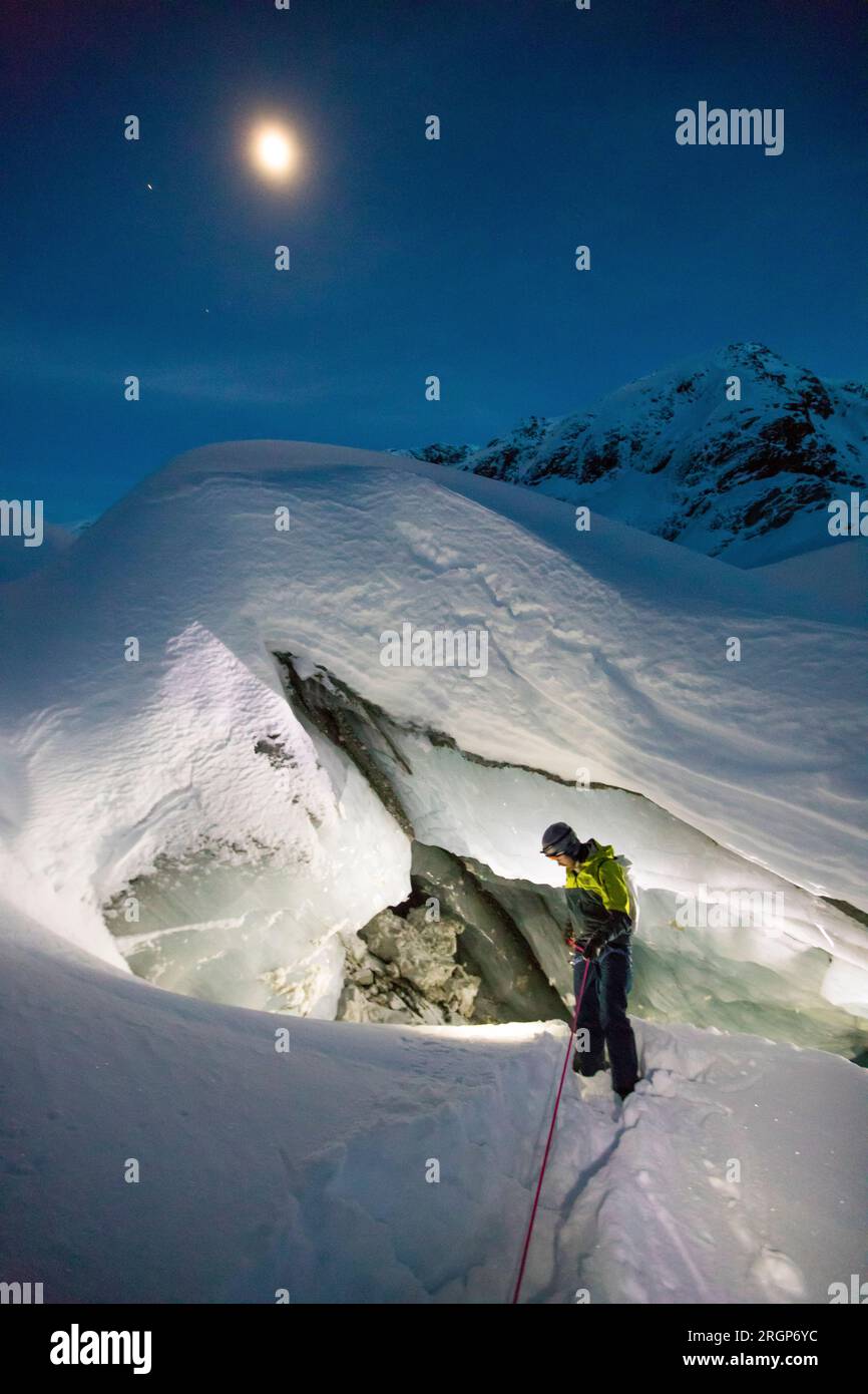 Explorer and ice climber rappels into glacial ice cave Stock Photo - Alamy