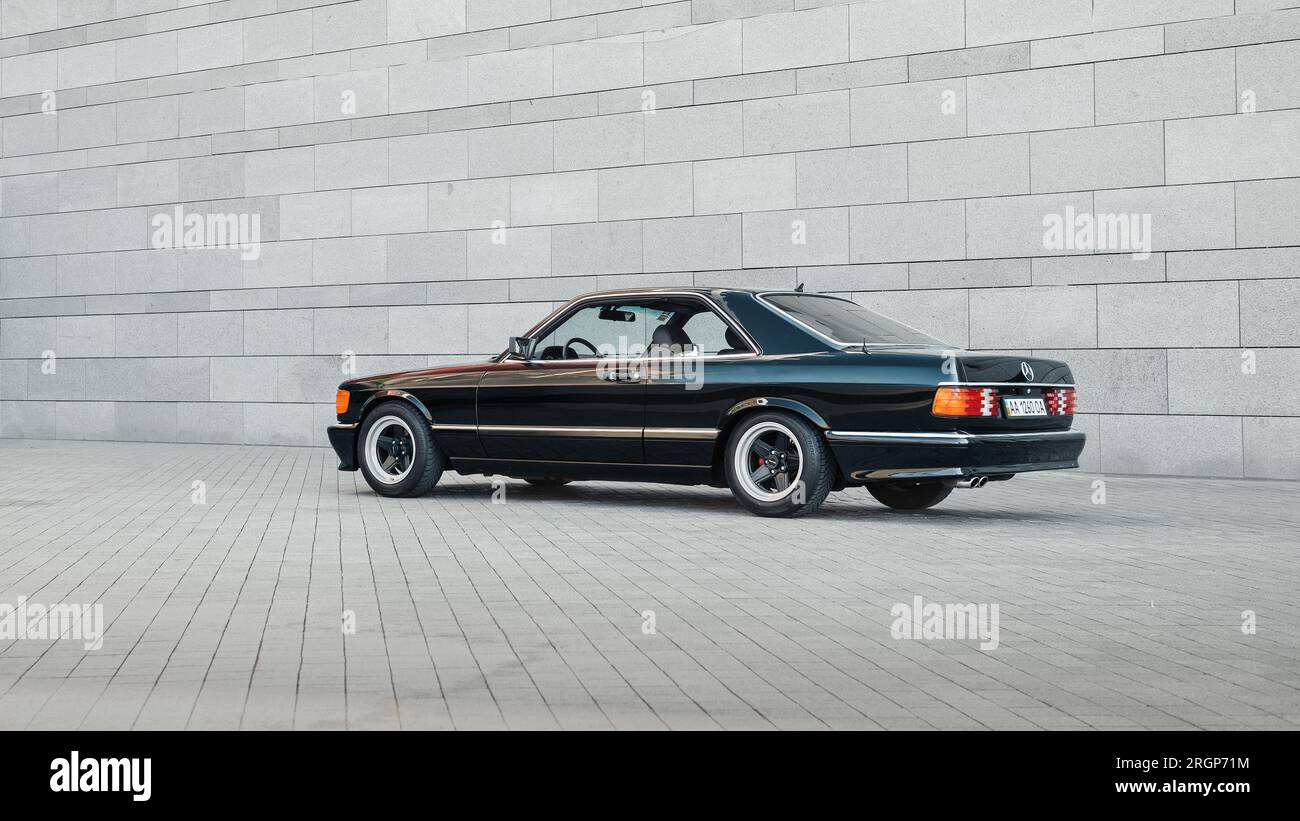 classic black Mercedes-Benz W126 in front of grey wall Stock Photo - Alamy