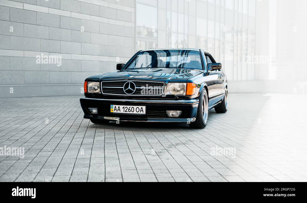 classic black Mercedes-Benz W126 parked near a generic office building ...