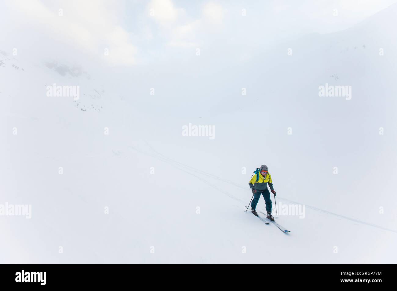 skier skinning up snow covered slope in a cloud Stock Photo - Alamy