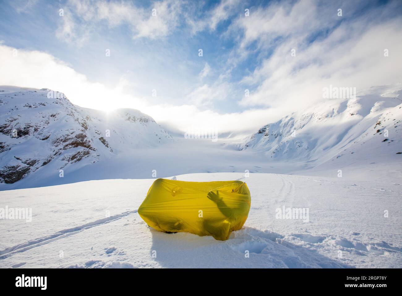 Two men sit, test out emergency tarp shelter in the mountains Stock ...