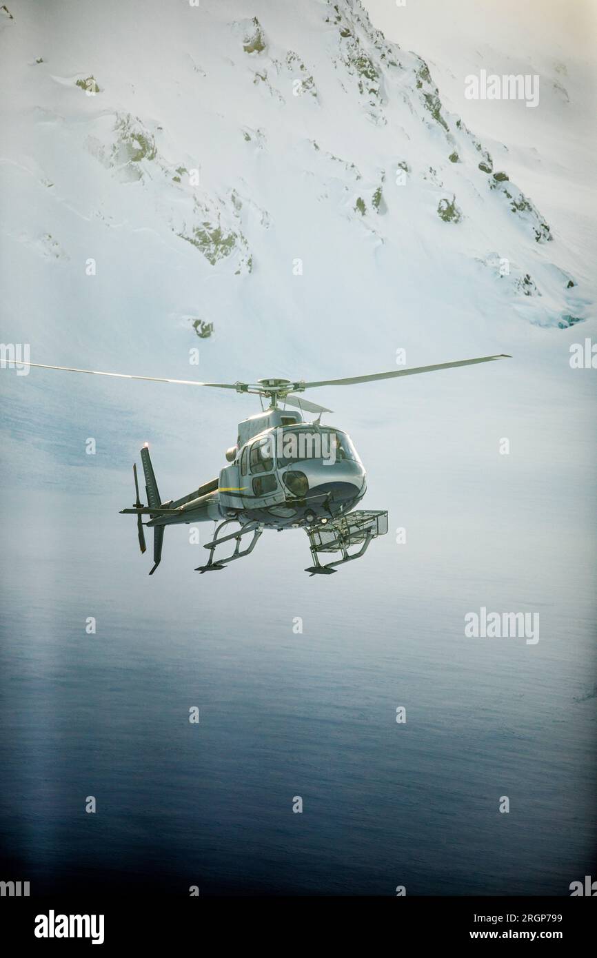 Helicopter flying low in snow covered mountains, canada Stock Photo - Alamy