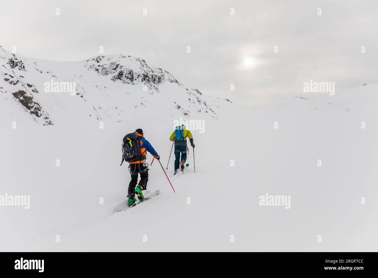 Rear view of two skiers touring up glacier in remote location Stock ...