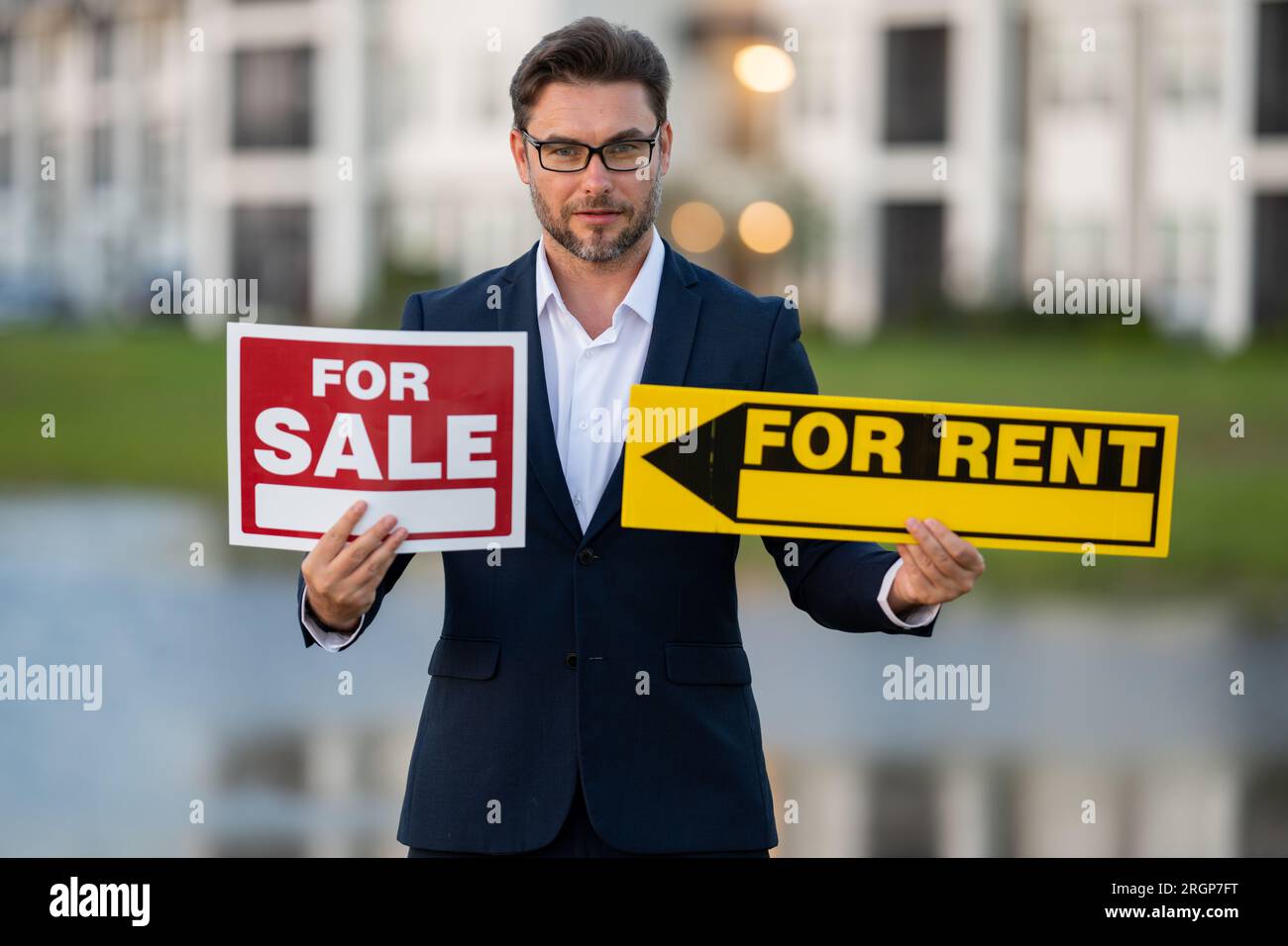 Successful real estate agent in suit with sign for sale and for rent ...