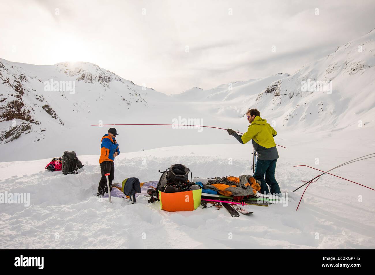 Two men set up tent on snow in remote mountain location Stock Photo - Alamy