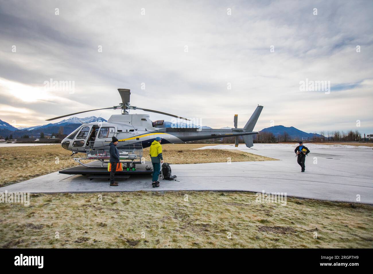 Three men prepare gear for flight in helicopter Stock Photo - Alamy