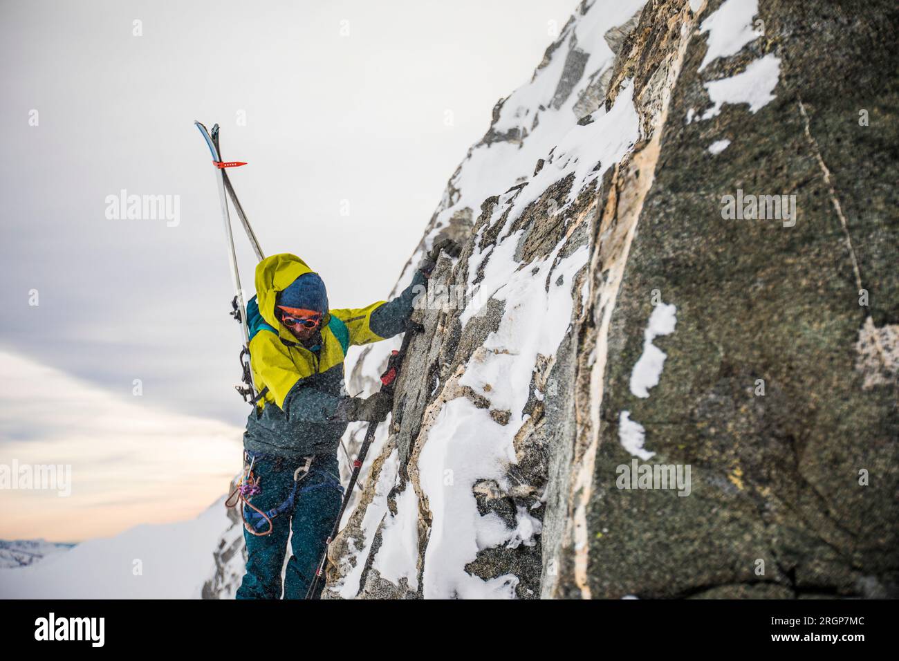 Skier carefully navigates a cliff face on approach to the summit Stock ...