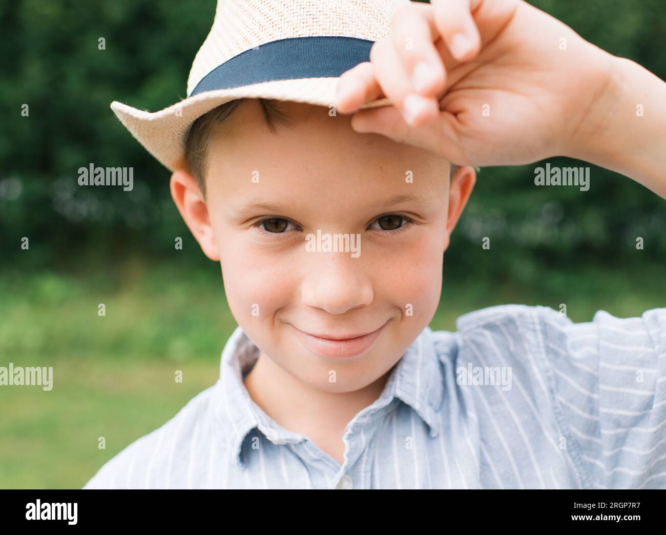 portrait of a boy looking cheeky with a summer hat on Stock Photo - Alamy