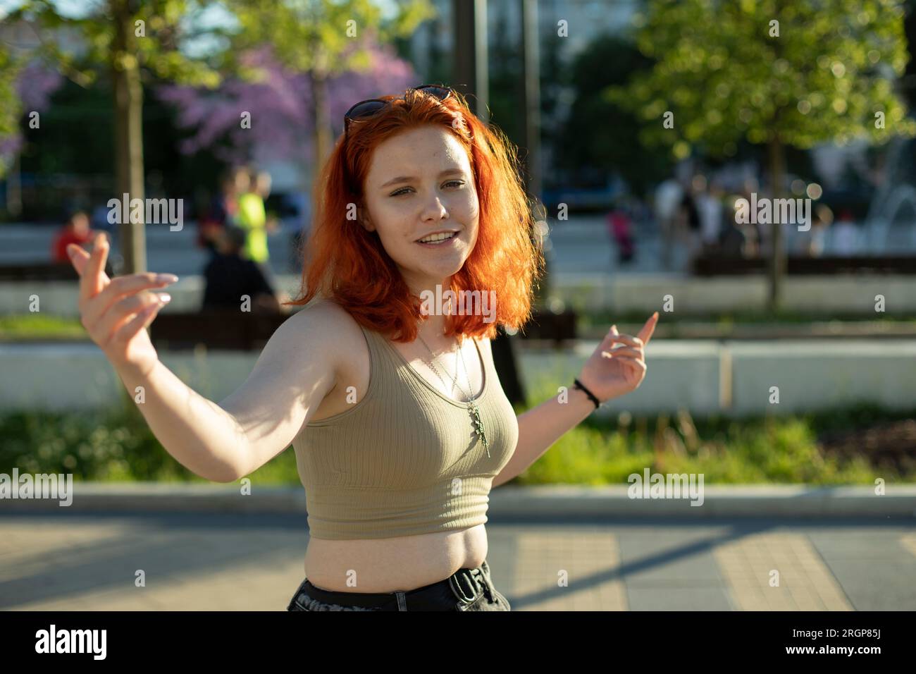 Girl waving her hands. Girl in summer. Woman in square Stock Photo - Alamy