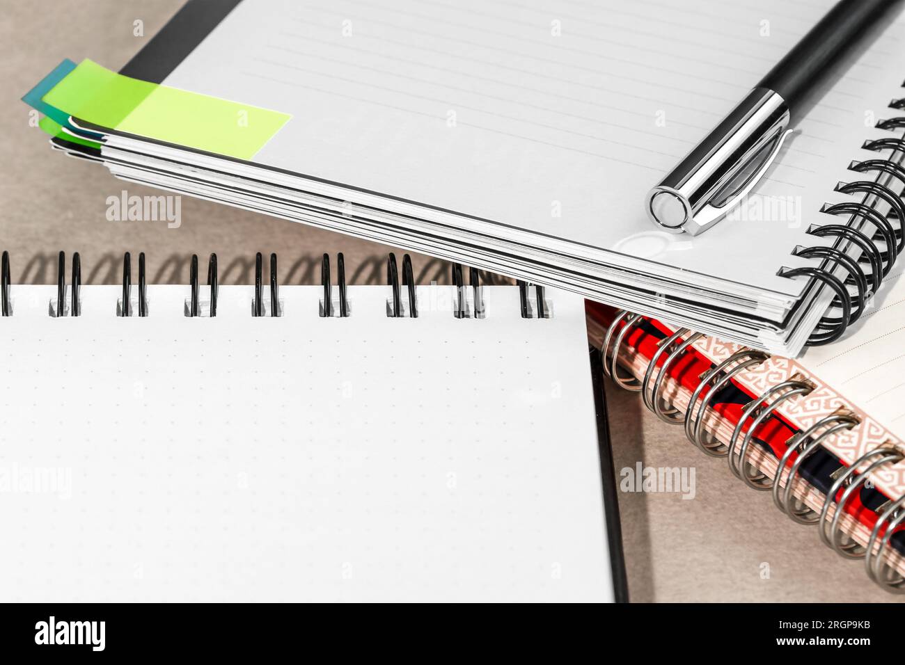 Several spiral notebooks and one pen lie on the office table Stock ...