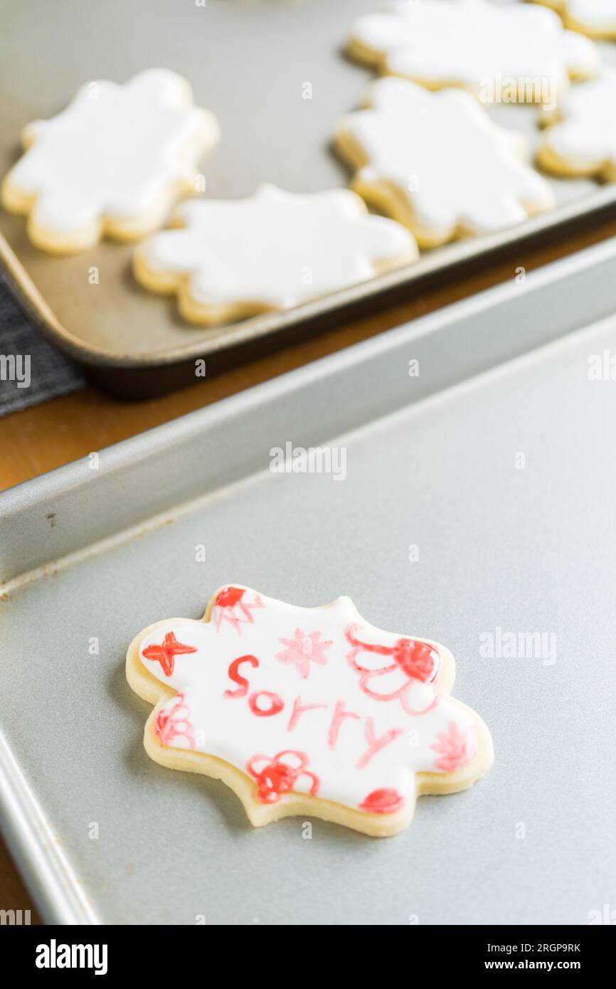 Little Girl Spells 'Sorry' on Iced Sugar Cookies Stock Photo - Alamy